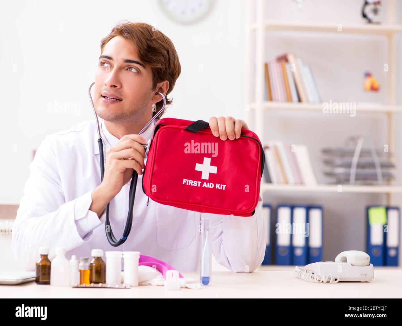 The young doctor with first aid kit in hospital Stock Photo - Alamy