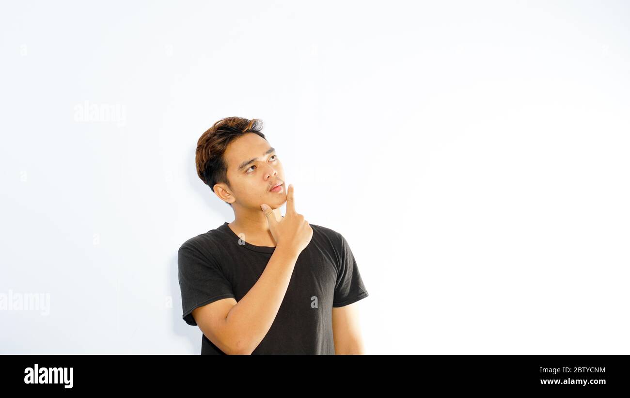 A portrait of a young asian man thinking looking up isolated over white ...