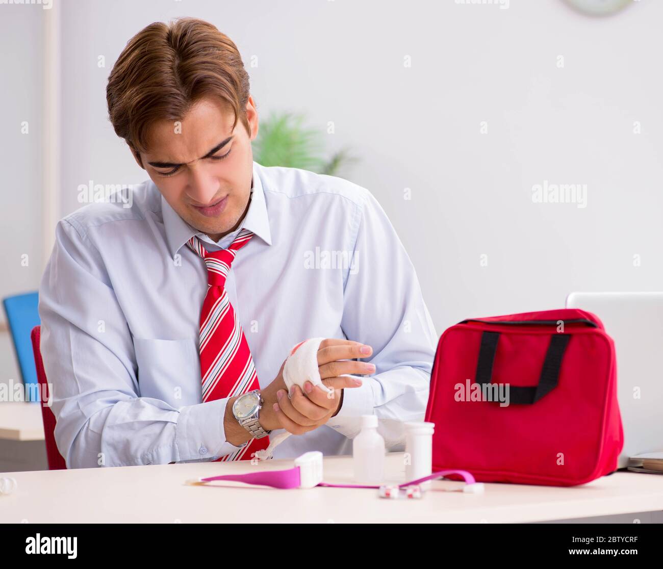 The man with first aid kit in the office Stock Photo - Alamy