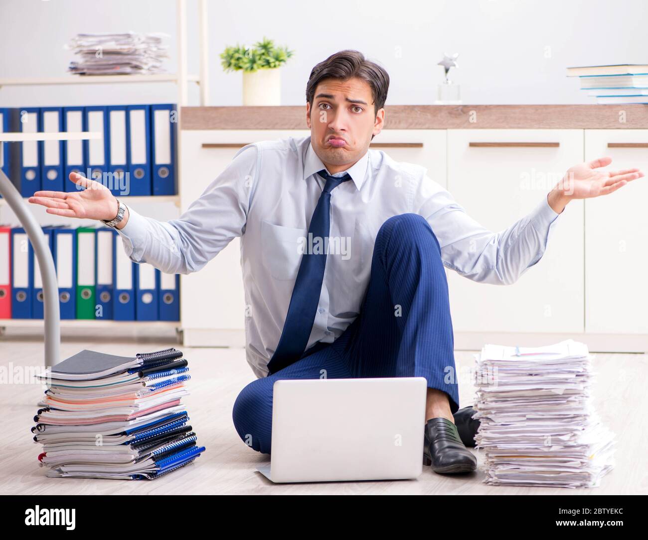The extremely busy employee working in the office Stock Photo - Alamy