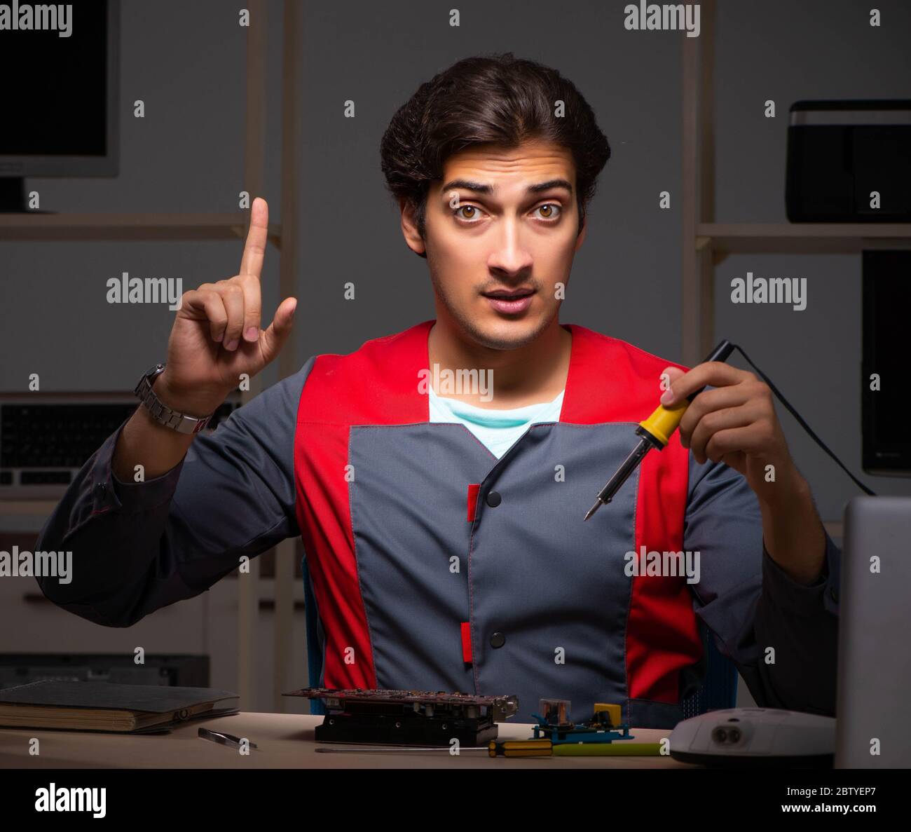 The young handsome repairman repairing computer Stock Photo - Alamy