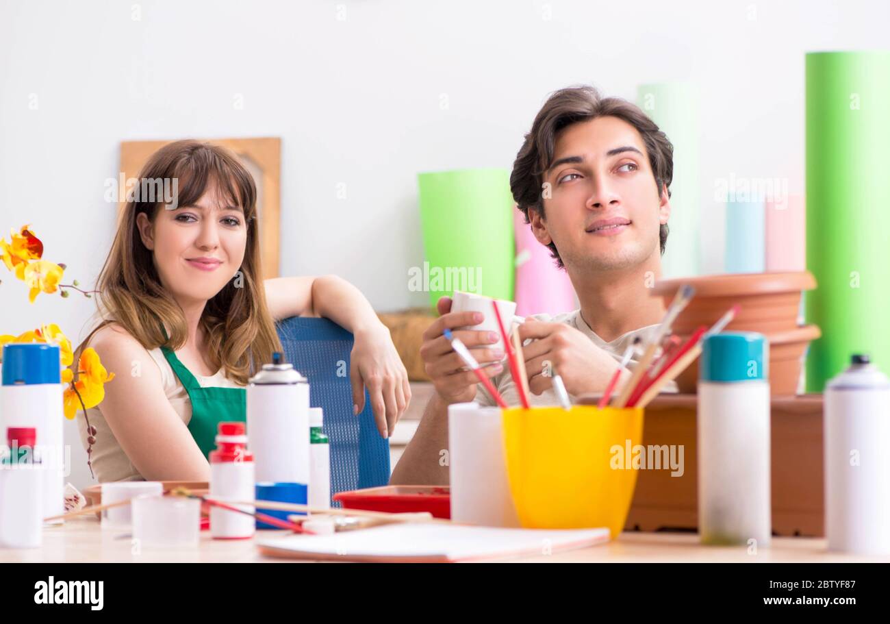 The couple decorating pots in workshop during class Stock Photo - Alamy