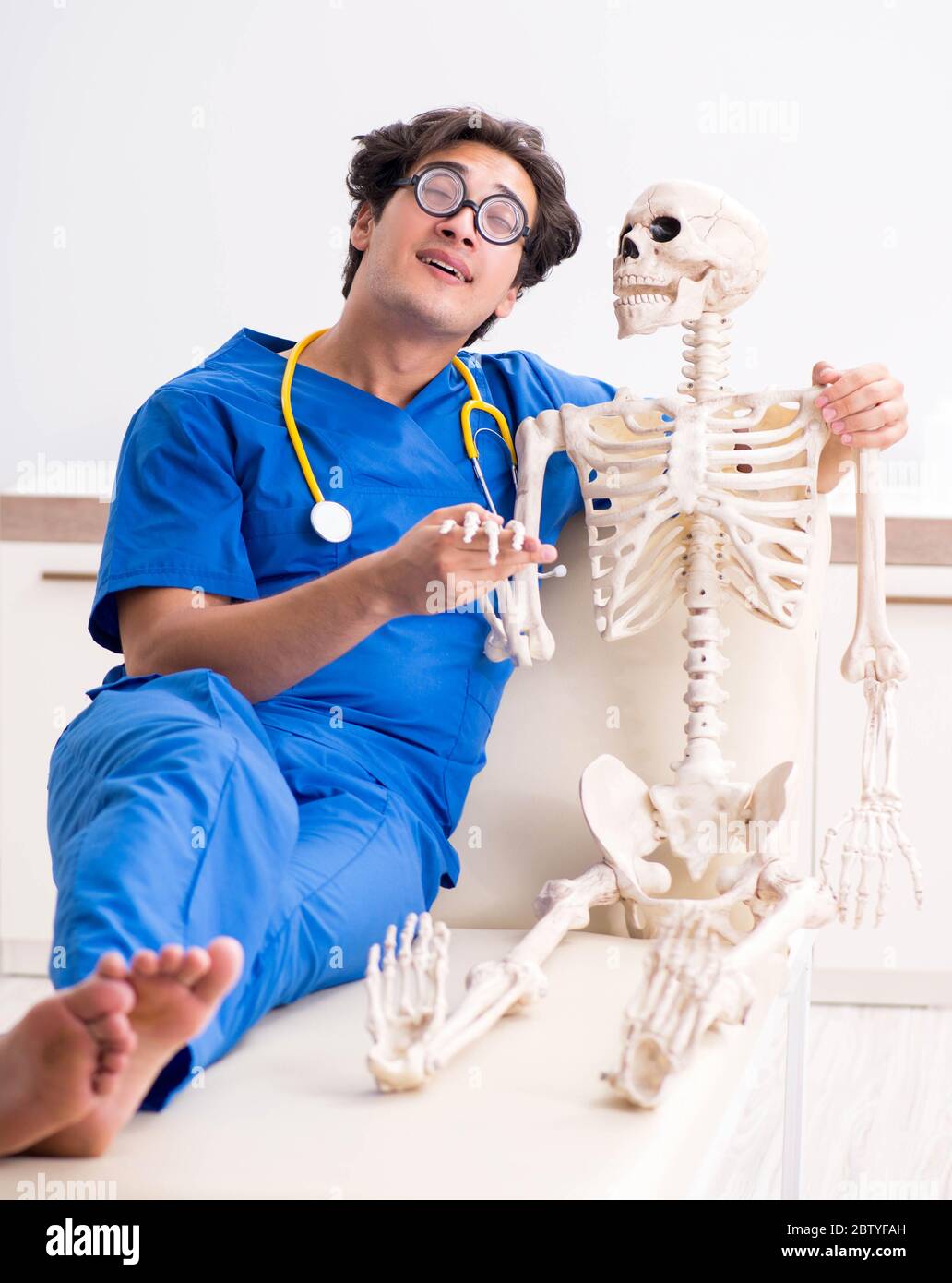 The funny doctor with skeleton in hospital Stock Photo - Alamy