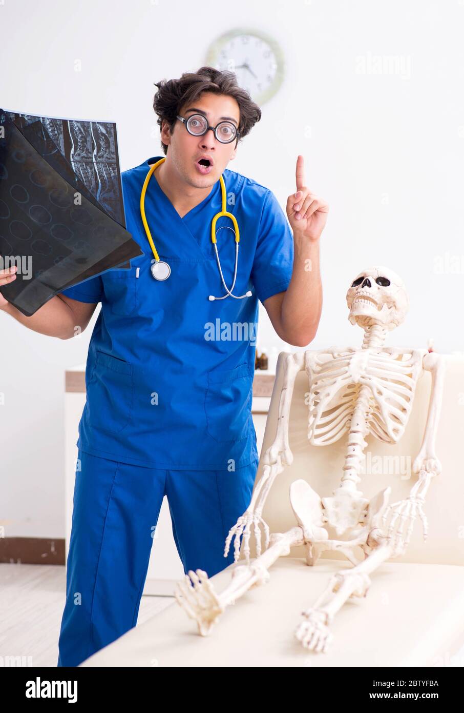 The funny doctor with skeleton in hospital Stock Photo - Alamy