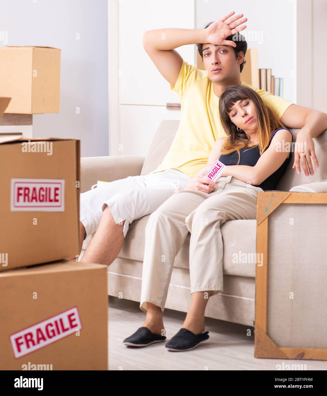 The young couple moving to new flat with fragile things Stock Photo - Alamy