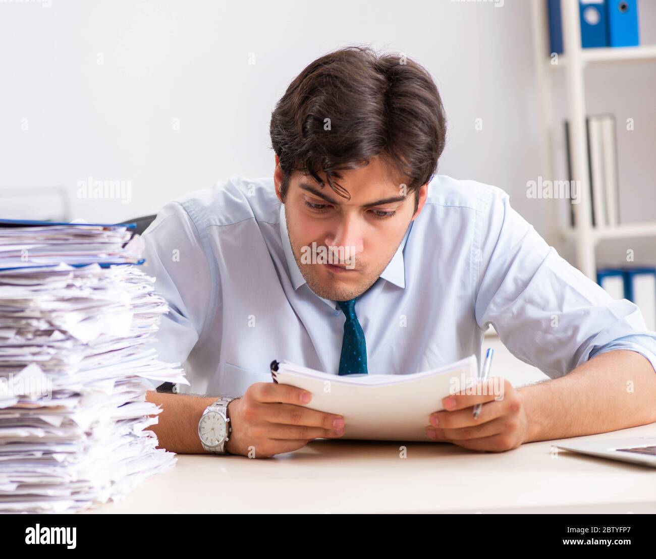 The overloaded busy employee with too much work and paperwork Stock ...