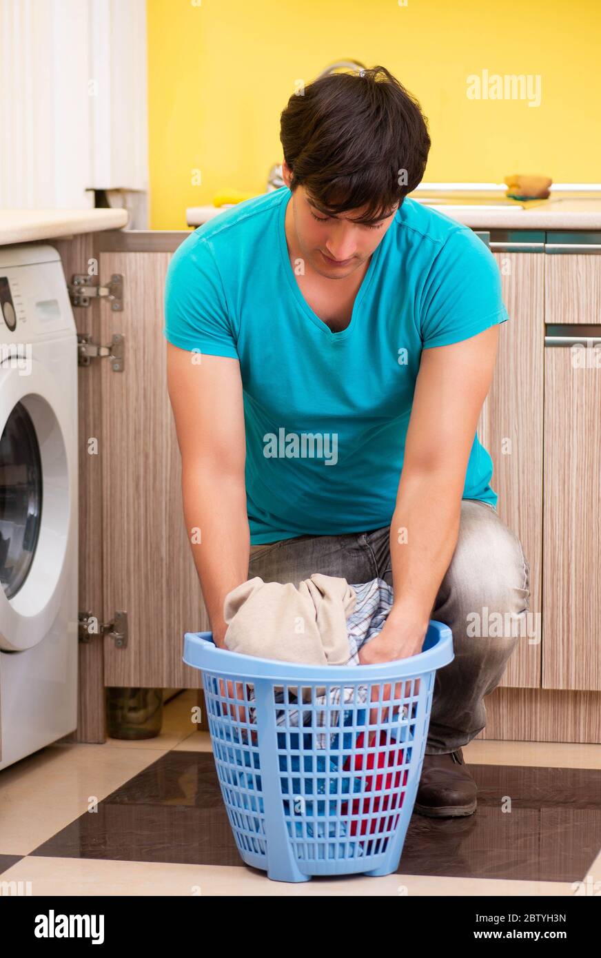 The young husband man doing laundry at home Stock Photo - Alamy
