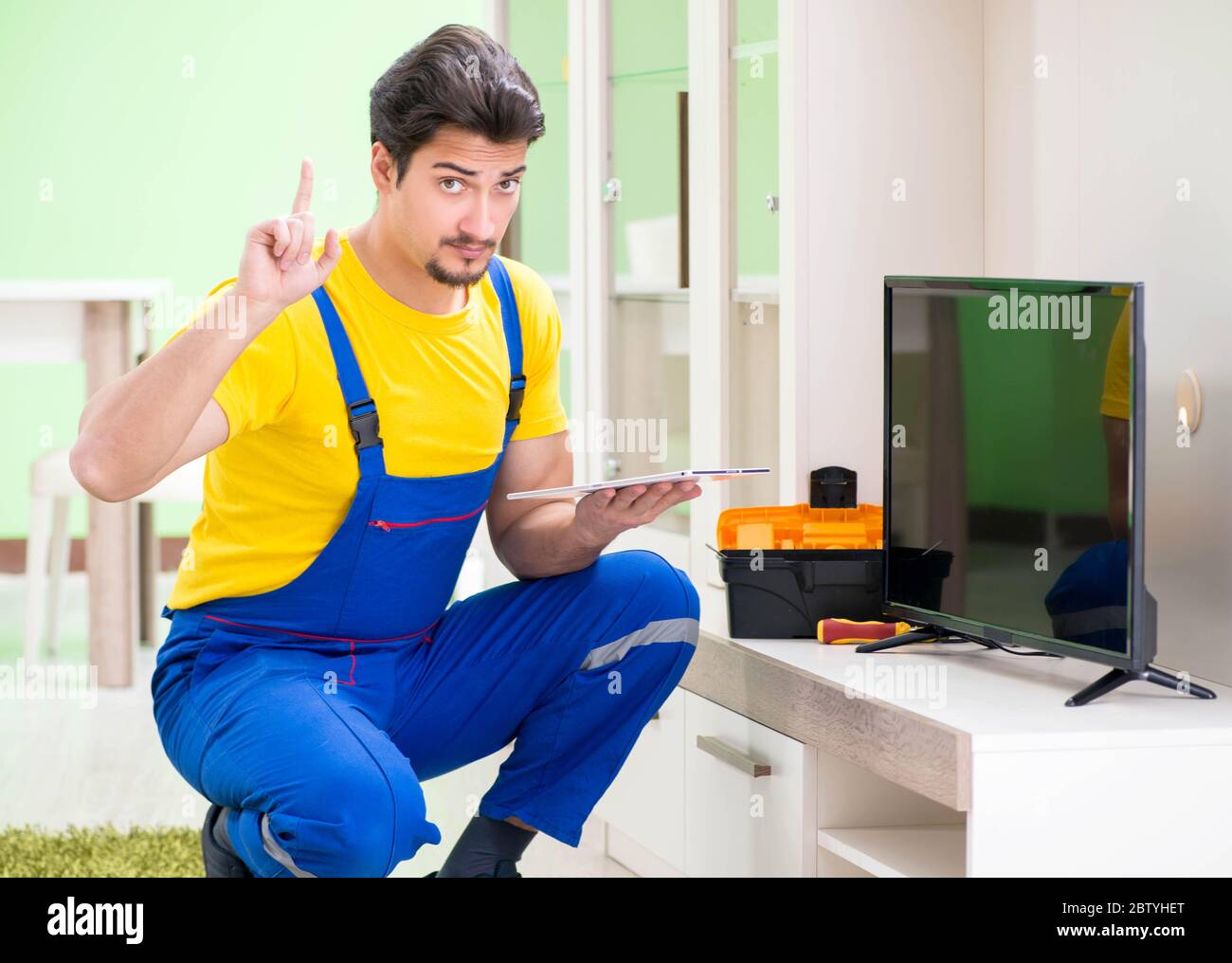 The male professional serviceman repairing tv at home Stock Photo - Alamy