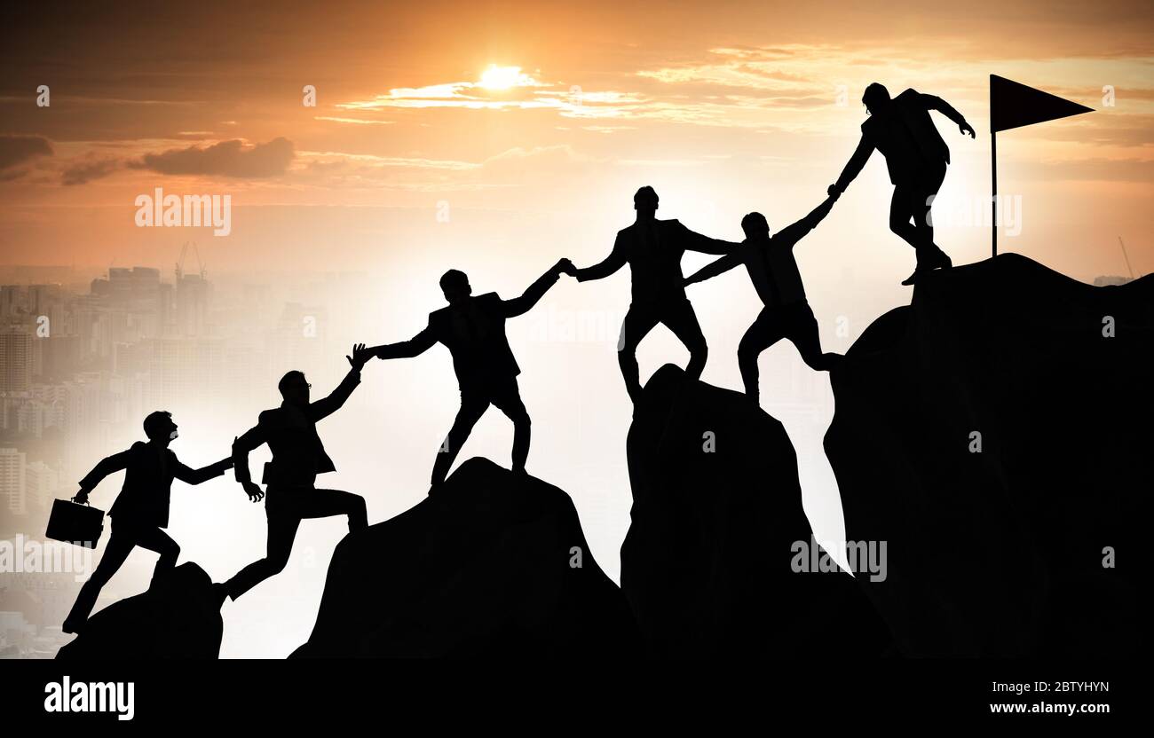 Concept of teamwork with the team climbing mountain top Stock Photo - Alamy