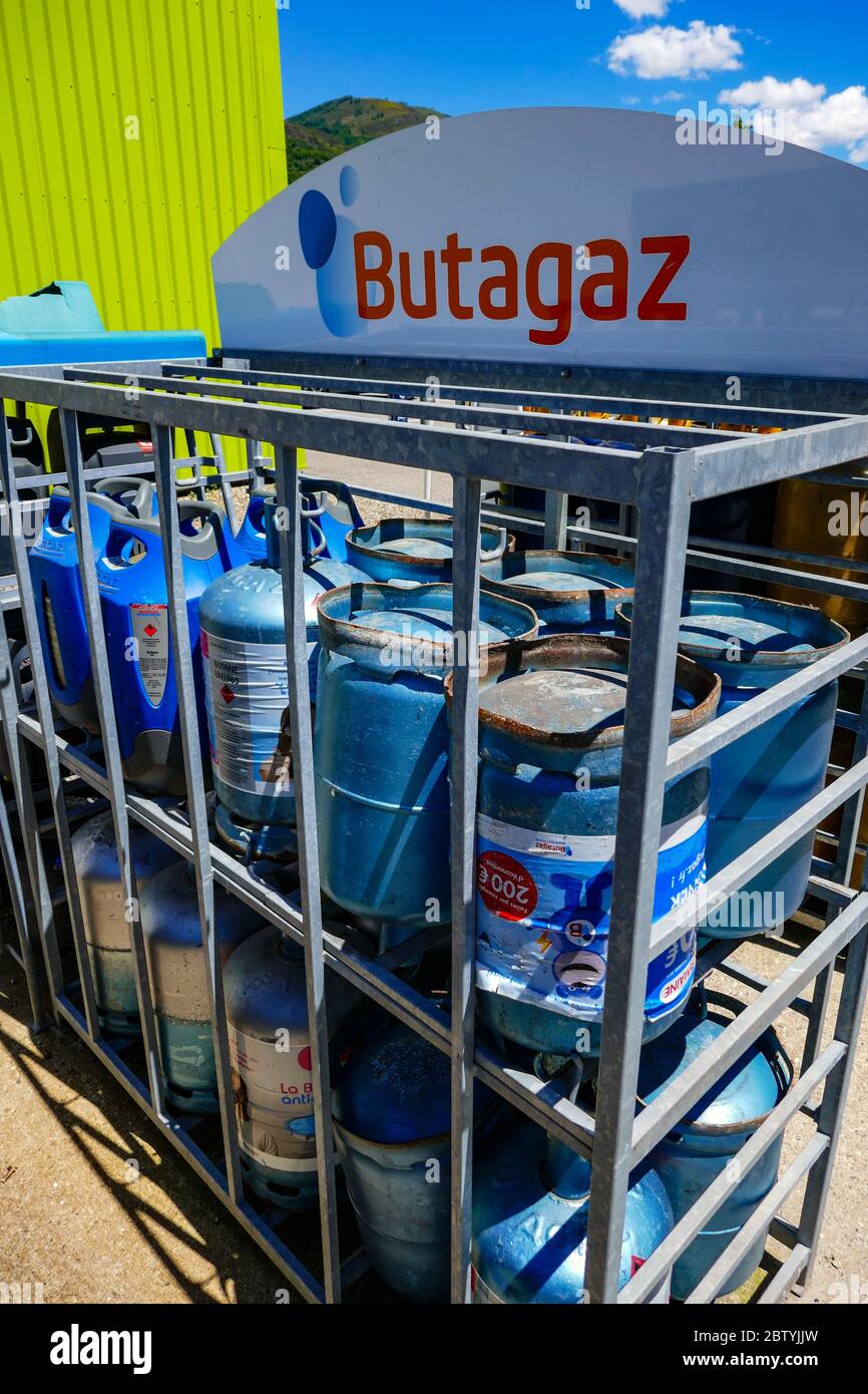 Bottled gas cylinders in rack, outside a supermarket in the Ariege ...