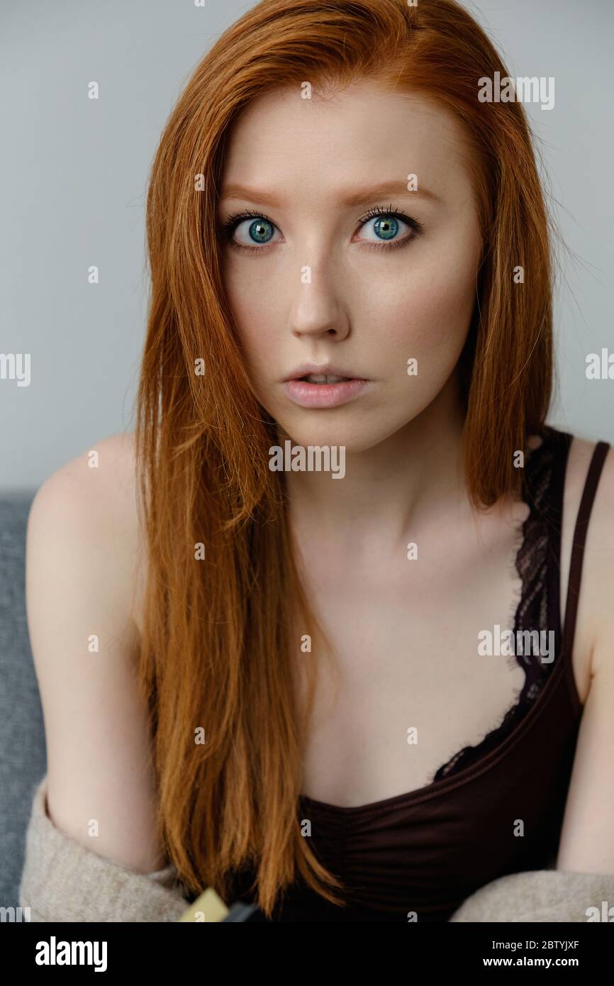 Close Portrait Of A Blue Eyed Red Haired Girl Looking At The Camera