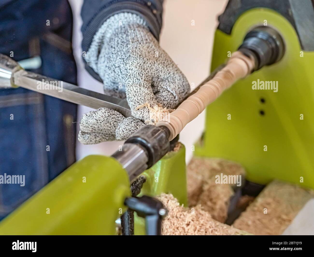 Carpenter man is carving the wooden stick. Spinning wood wheel machine ...