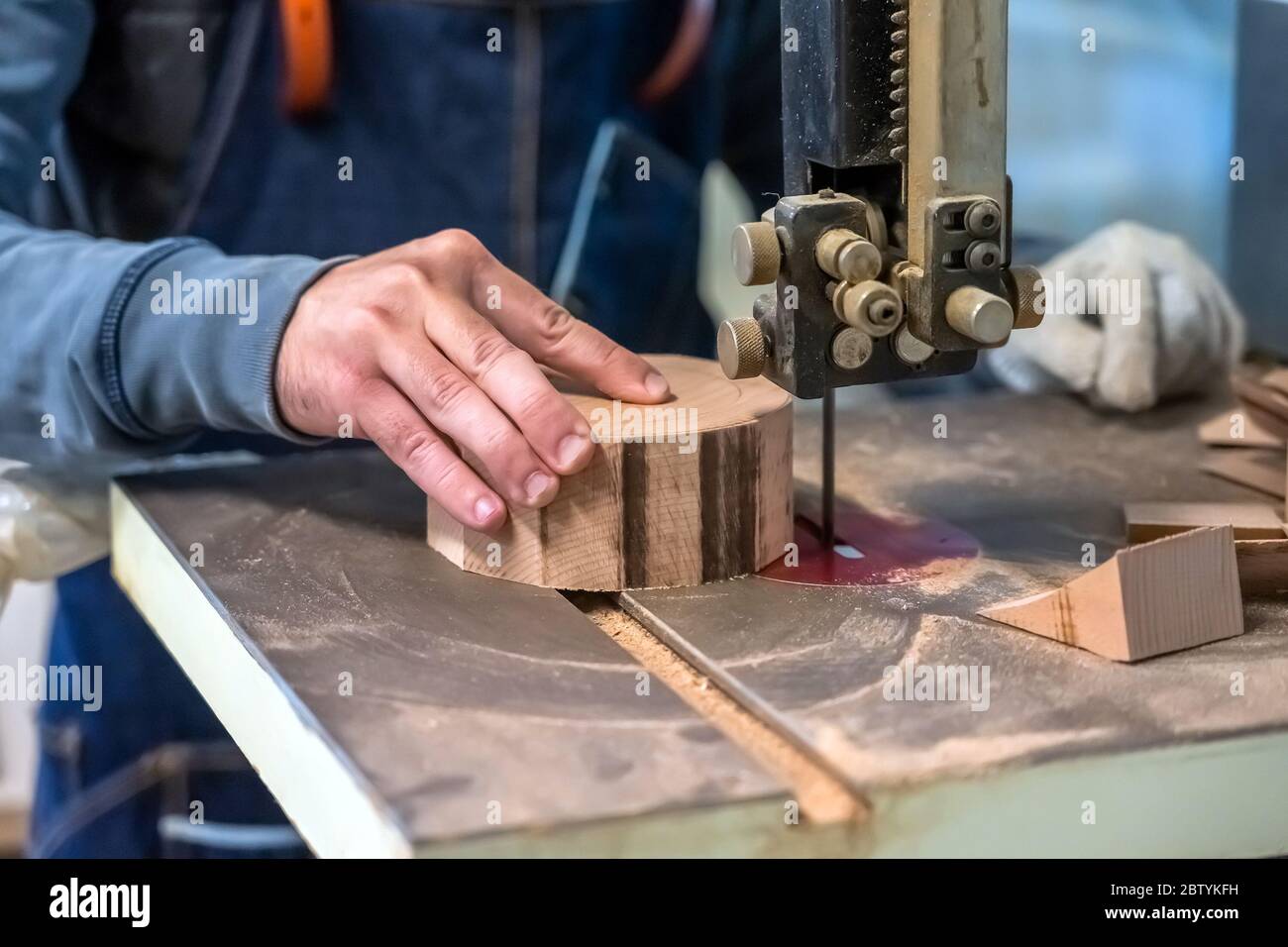 Carpenter is cutting the wooden piece by equipment on stand. The man's ...