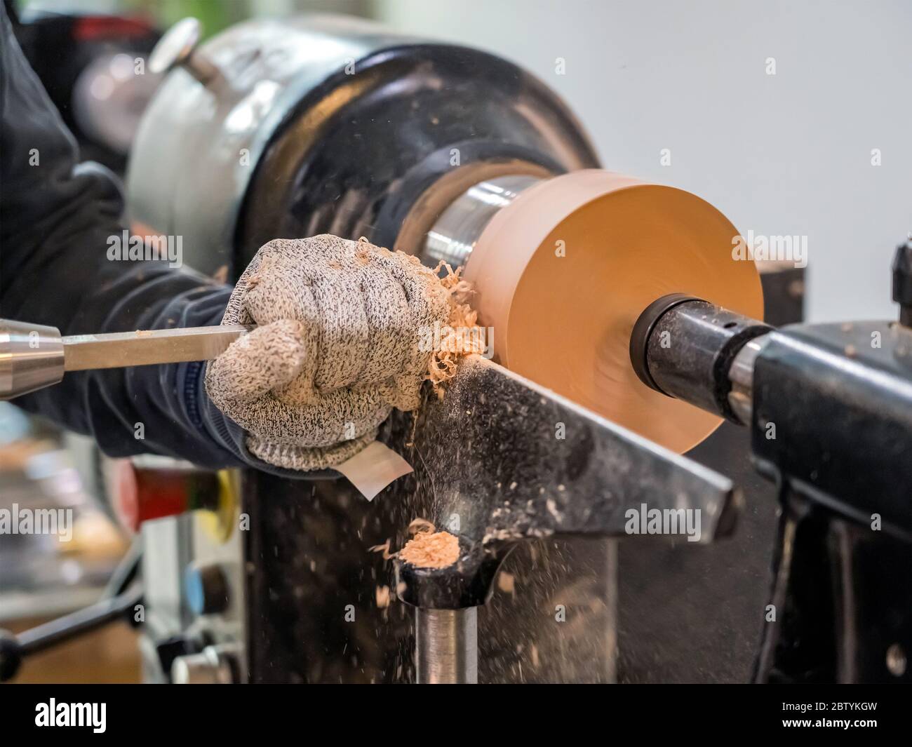 Carpenter man is shaving surface of the wooden bowl. Spinning wood ...