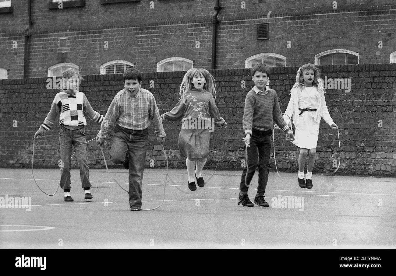 Primary school children skipping in the playground, England, May 1985 ...