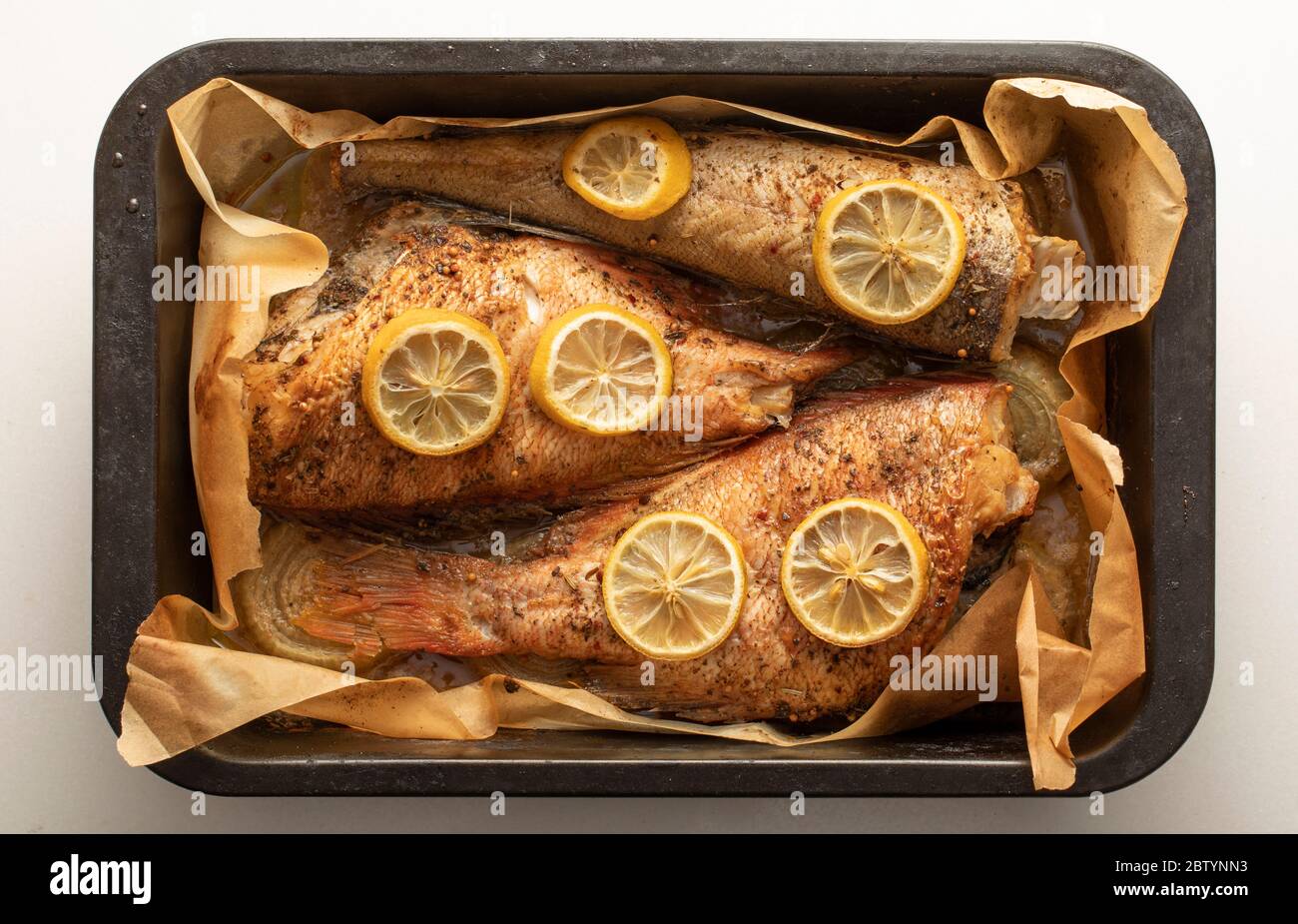 Baked fish in a baking dish on a white background Stock Photo - Alamy
