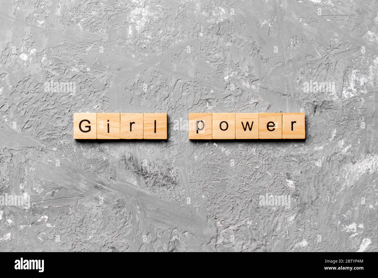Girl Power word written on wood block. Girl Power text on cement table ...