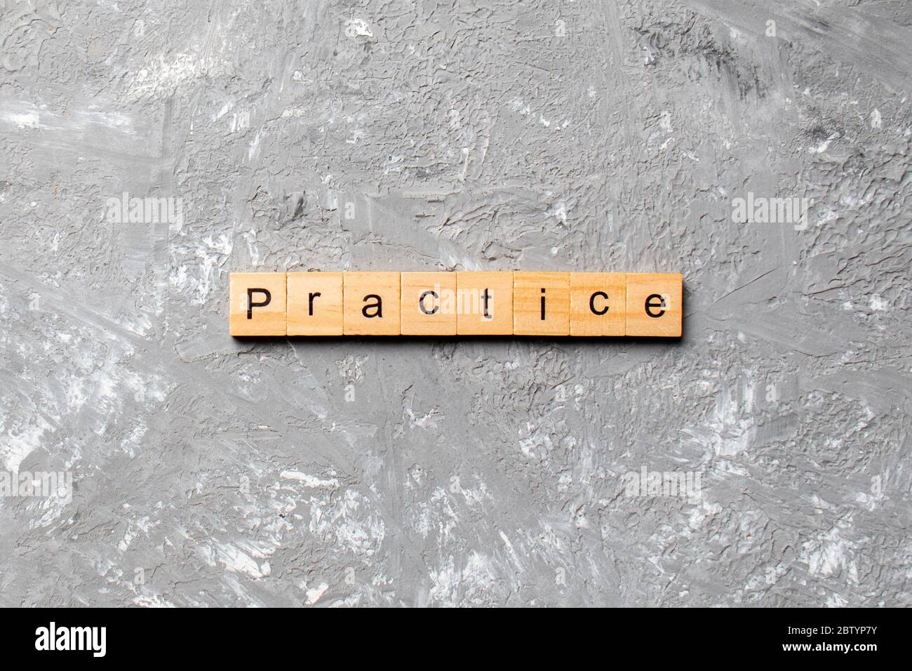 practice word written on wood block. practice text on table, concept ...
