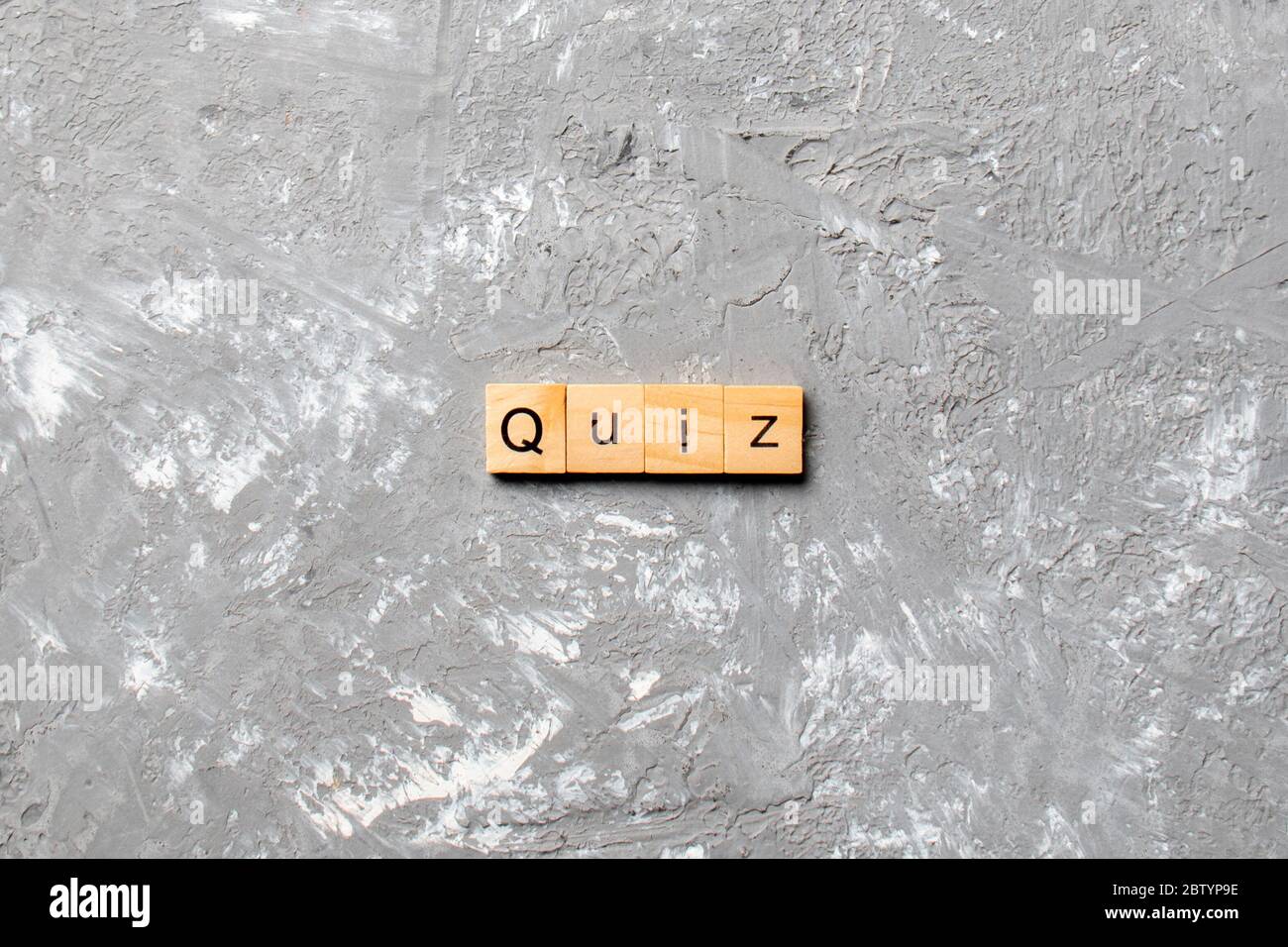 Quiz word written on wood block. Quiz text on cement table for your ...
