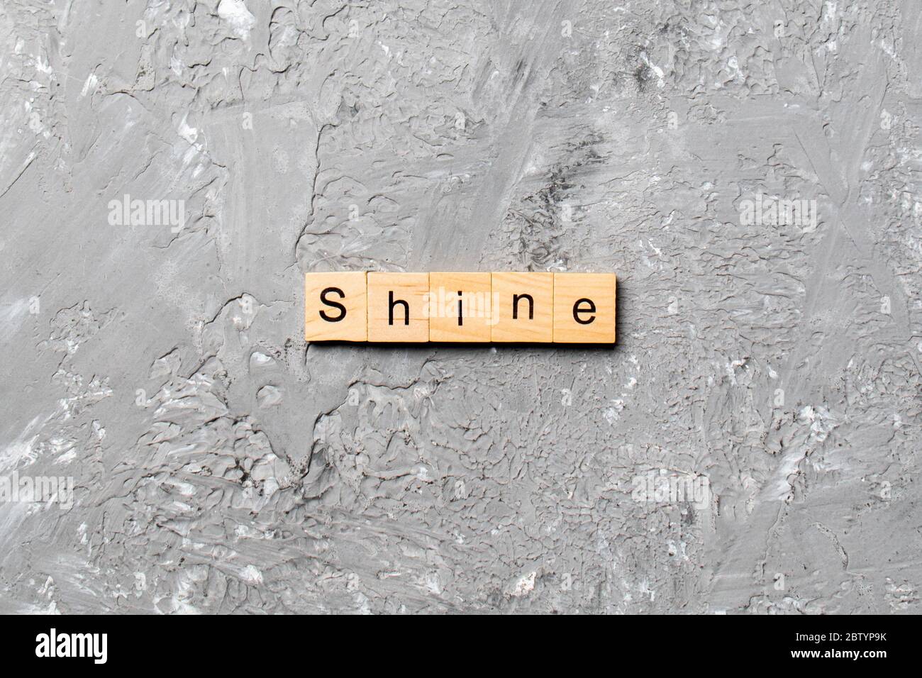 Shine word written on wood block. Shine text on cement table for your ...