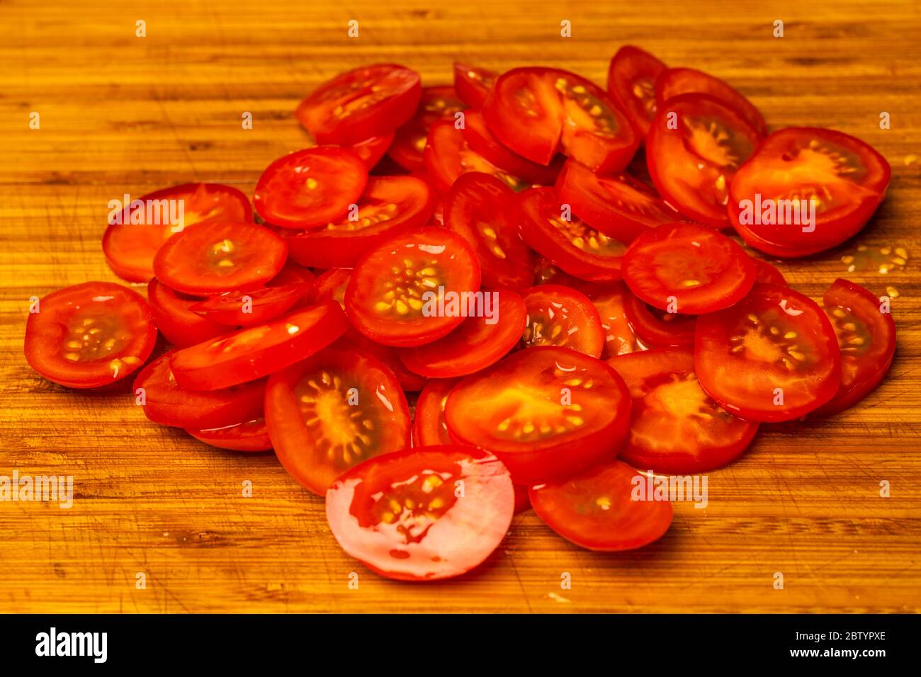 sliced tomatoes for a salad on the wooden board Stock Photo - Alamy