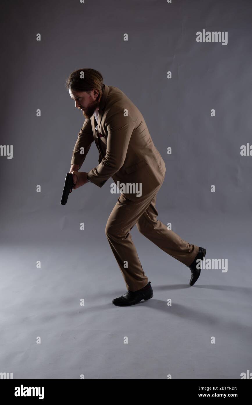 Isolated image of an undercover cop with a gun against a plain ...