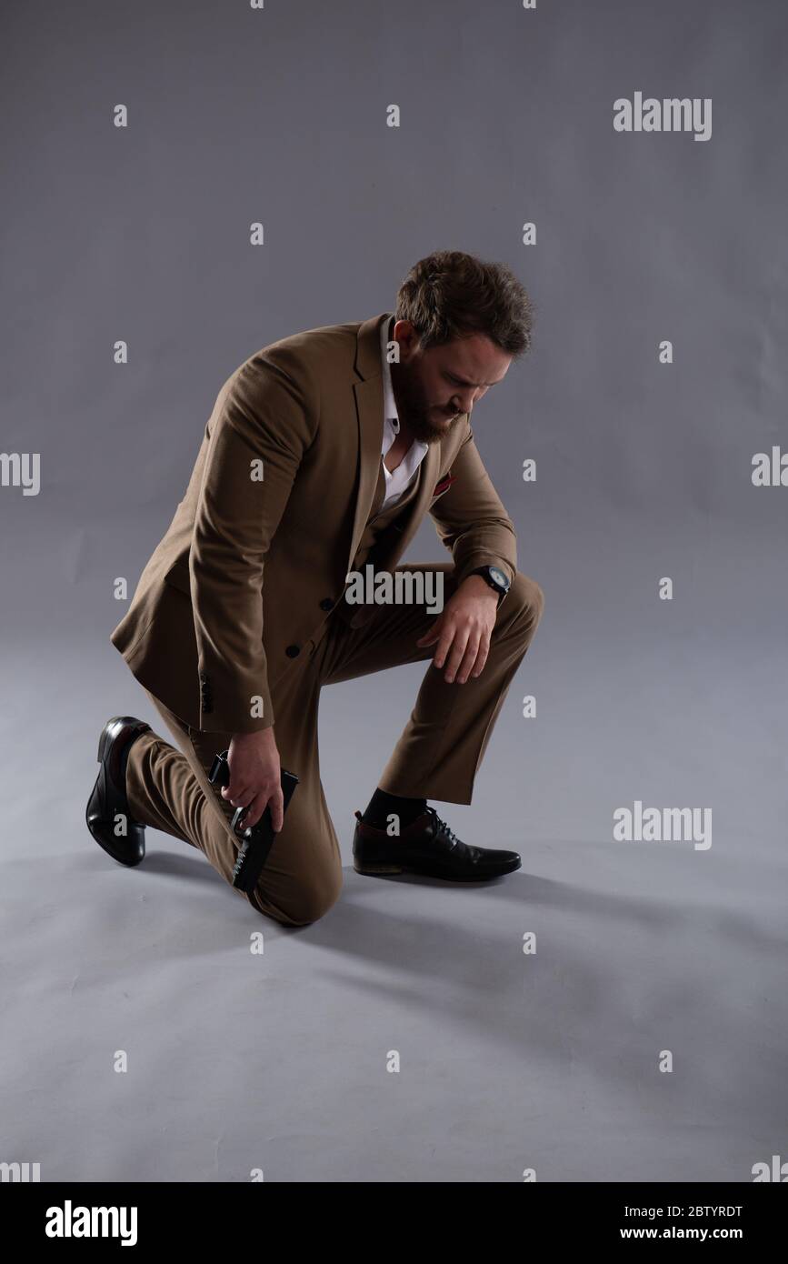 Isolated image of an undercover cop with a gun against a plain ...