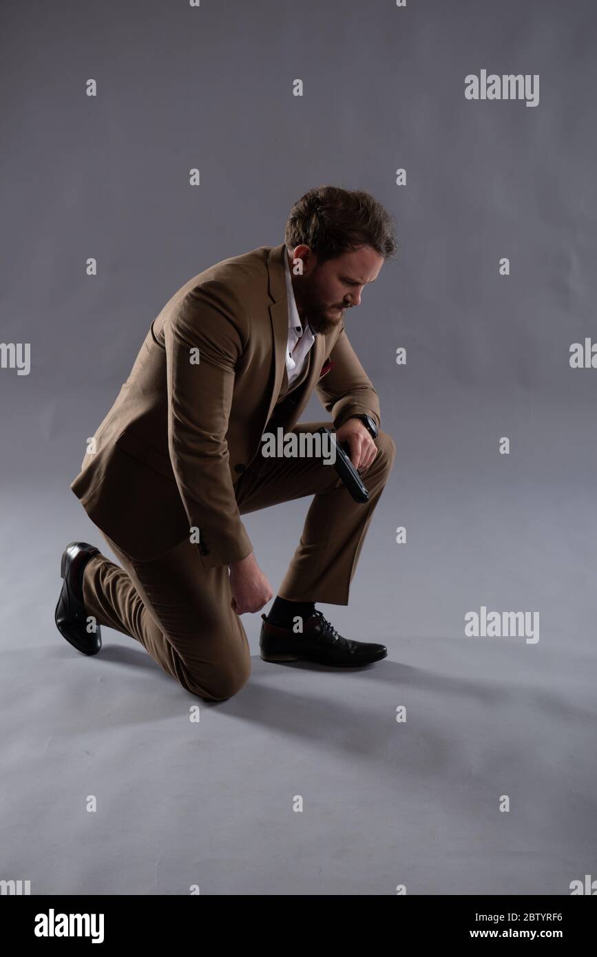 Isolated image of an undercover cop with a gun against a plain ...