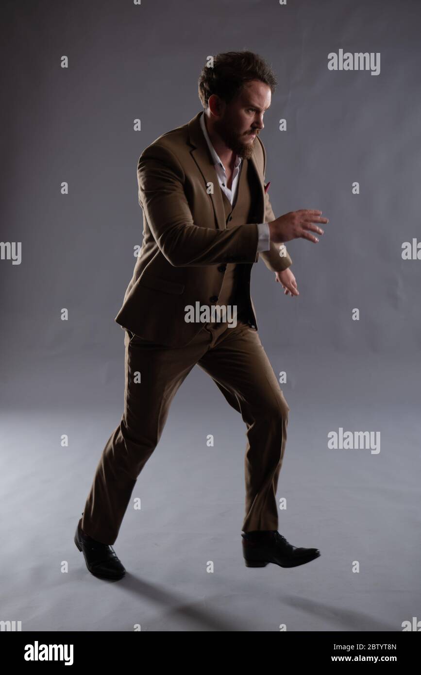 Isolated image of an undercover cop with a gun against a plain ...