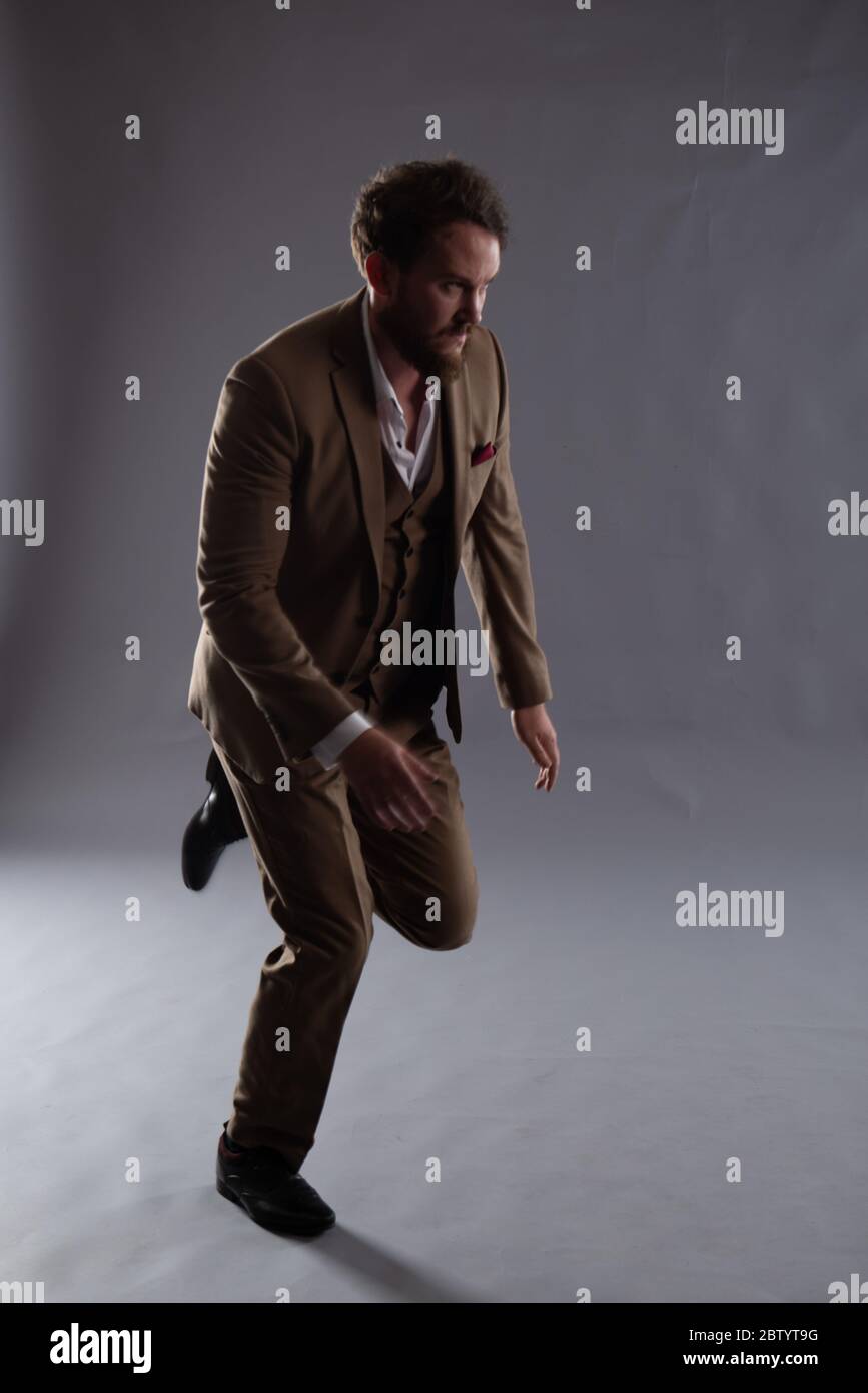 Isolated image of an undercover cop with a gun against a plain ...