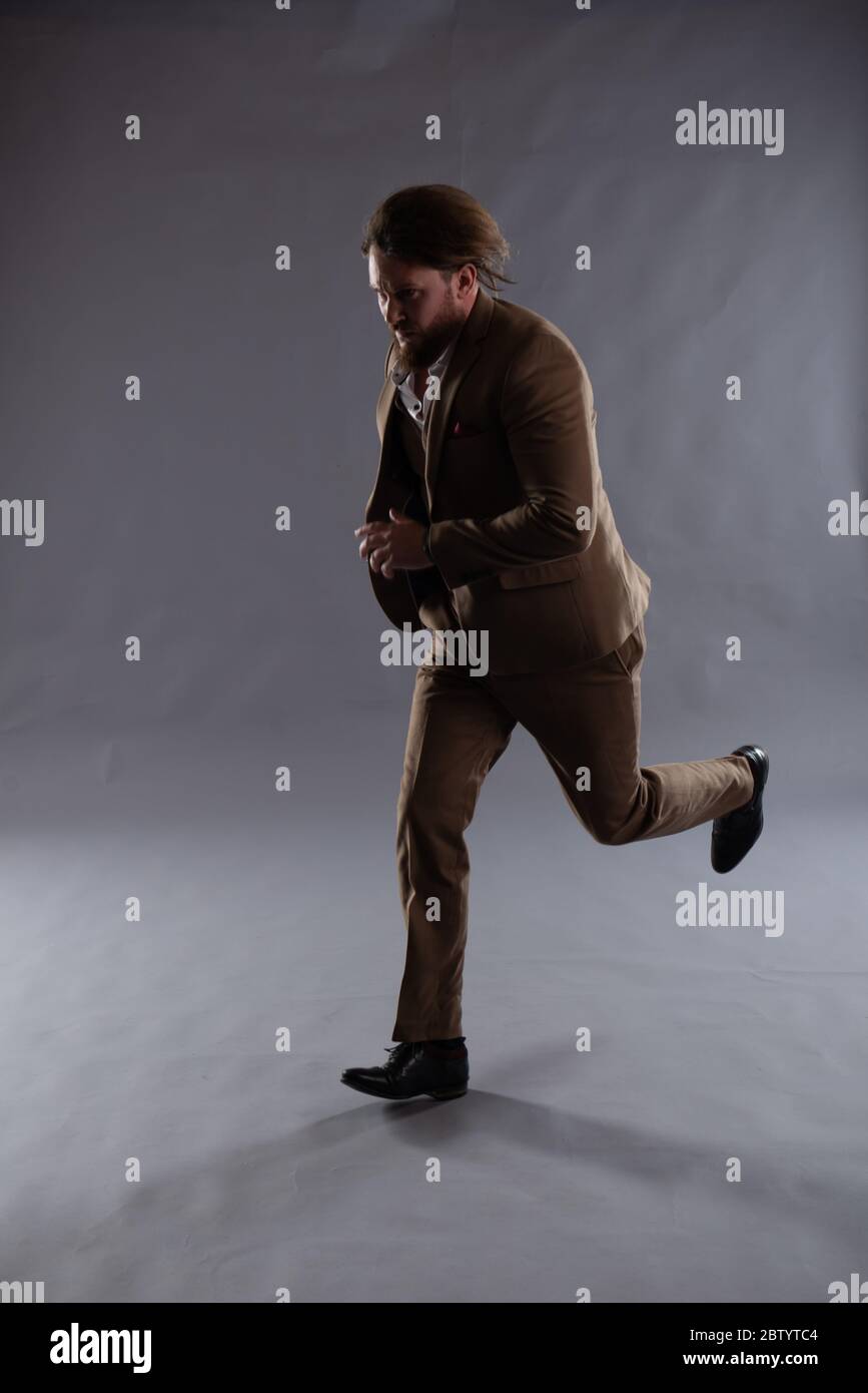 Isolated image of an undercover cop with a gun against a plain ...