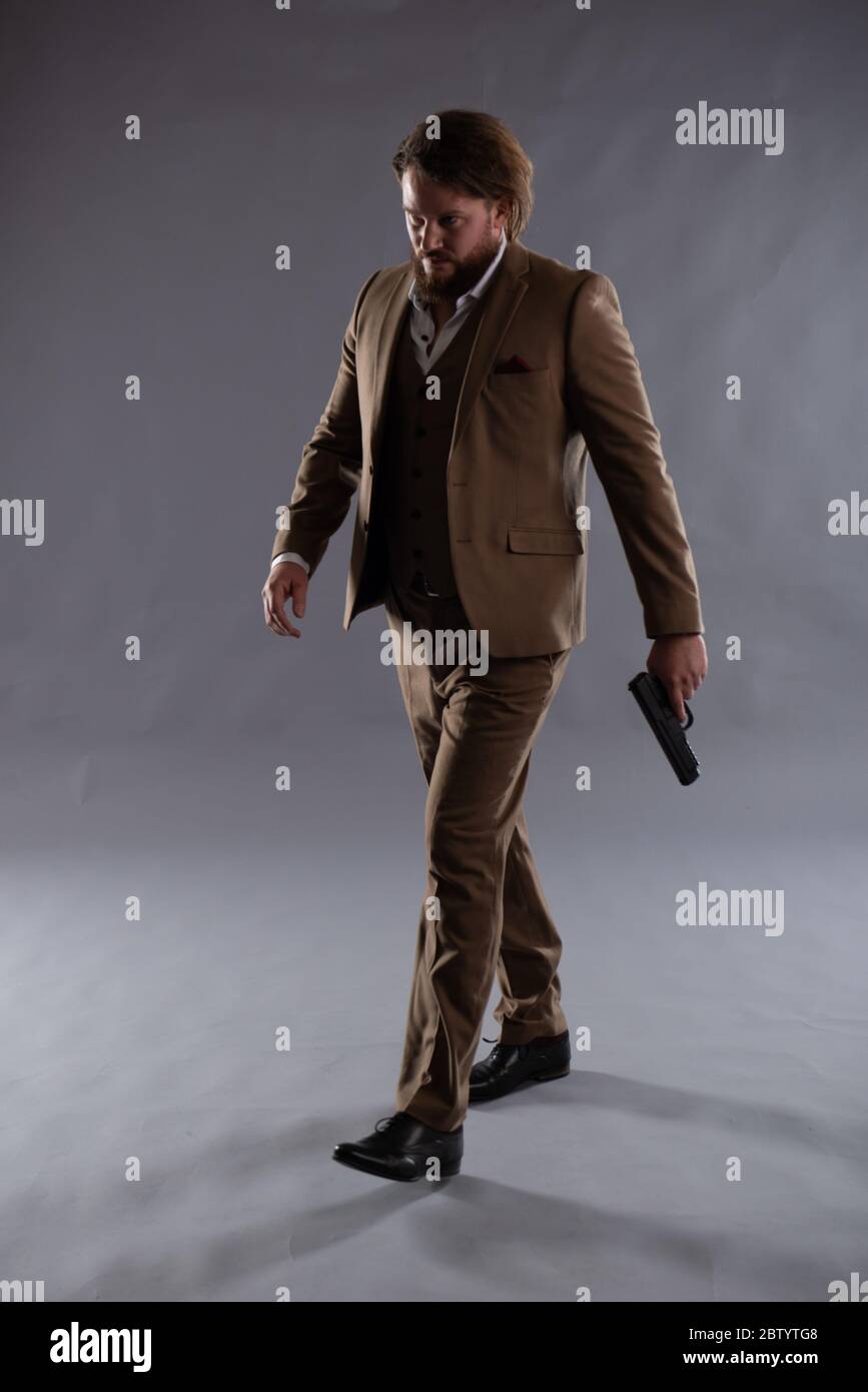 Isolated image of an undercover cop with a gun against a plain ...