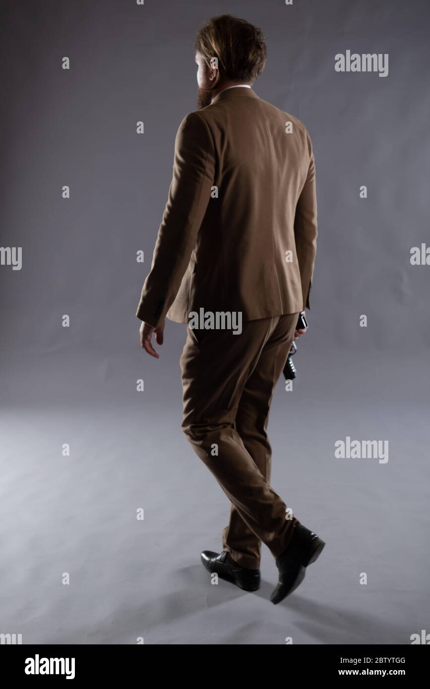 Isolated image of an undercover cop with a gun against a plain ...