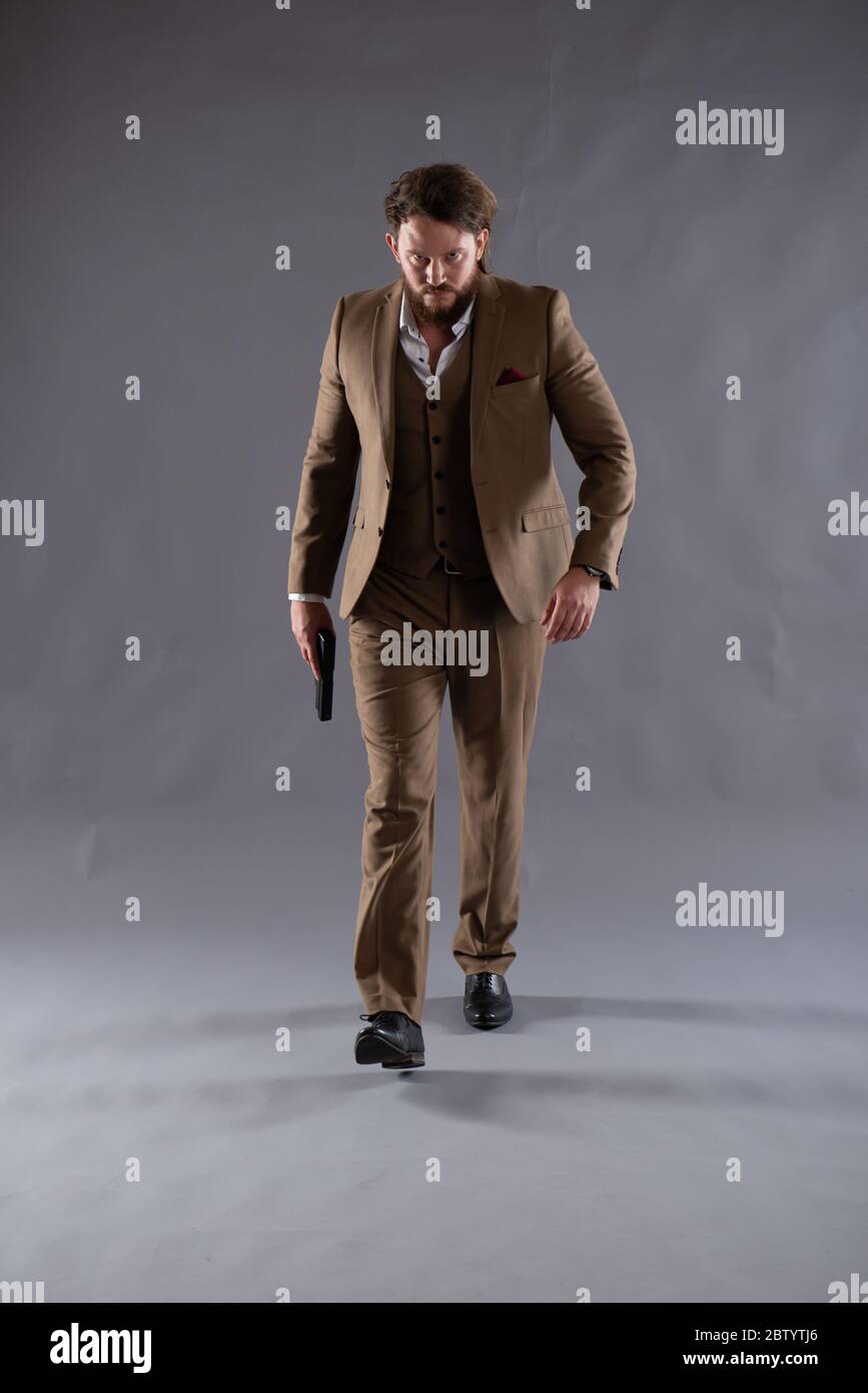 Isolated image of an undercover cop with a gun against a plain ...