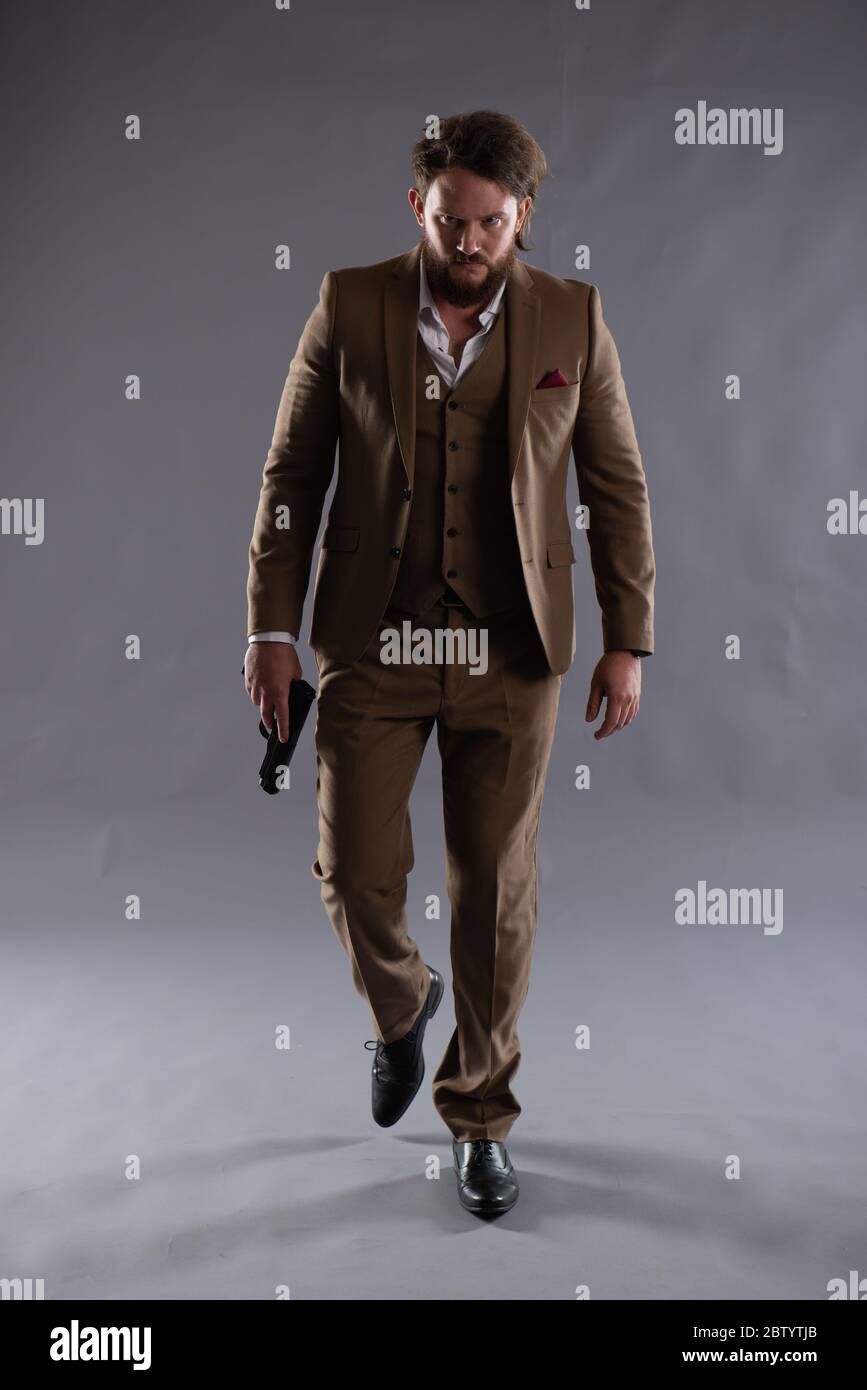 Isolated image of an undercover cop with a gun against a plain ...