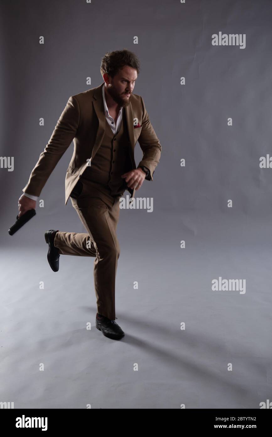 Man running suit gun hi-res stock photography and images - Alamy