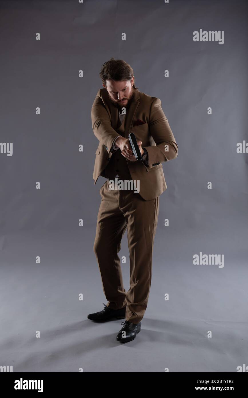 Isolated image of an undercover cop with a gun against a plain ...