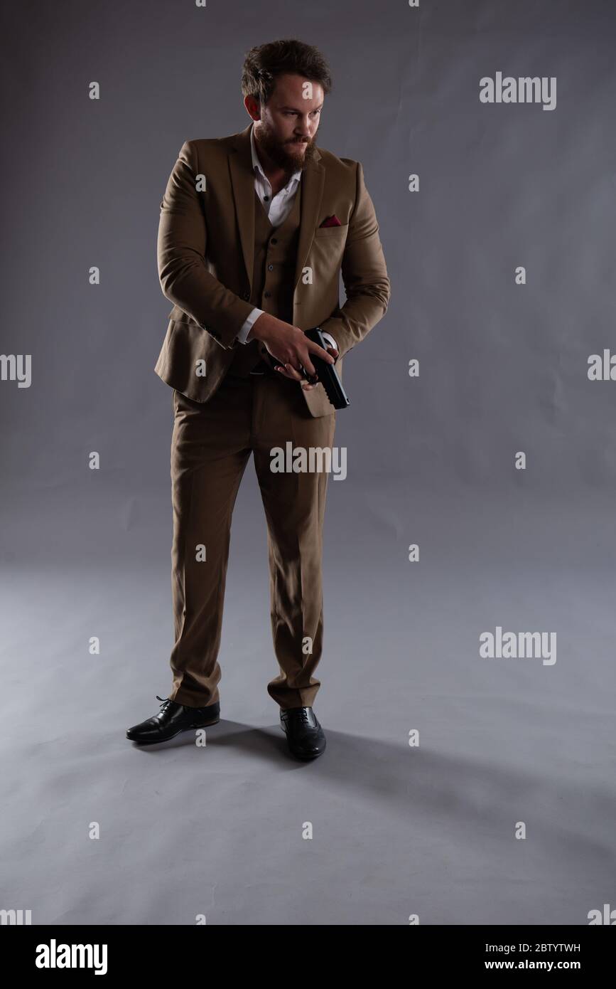 Isolated image of an undercover cop with a gun against a plain ...