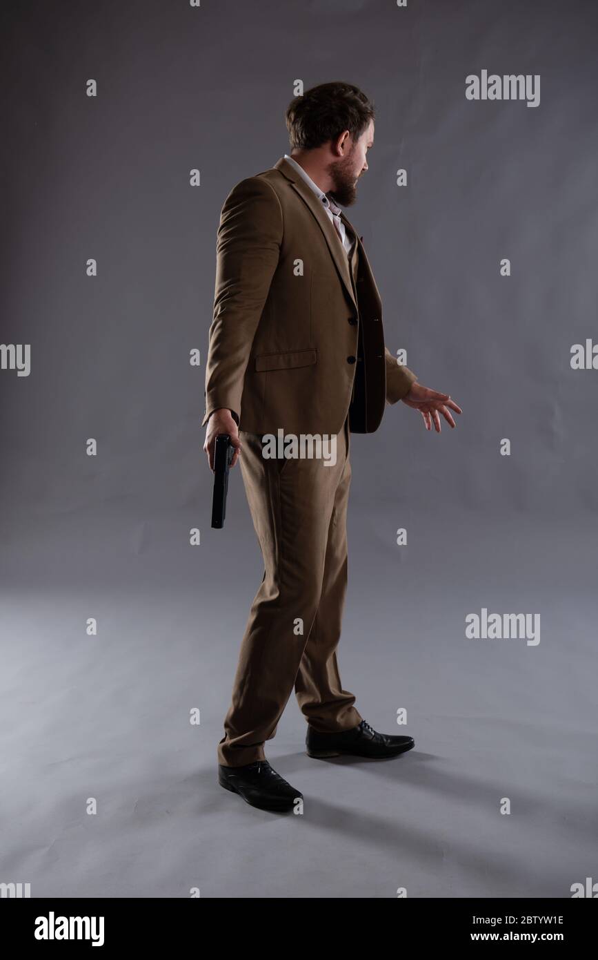 Isolated image of an undercover cop with a gun against a plain ...