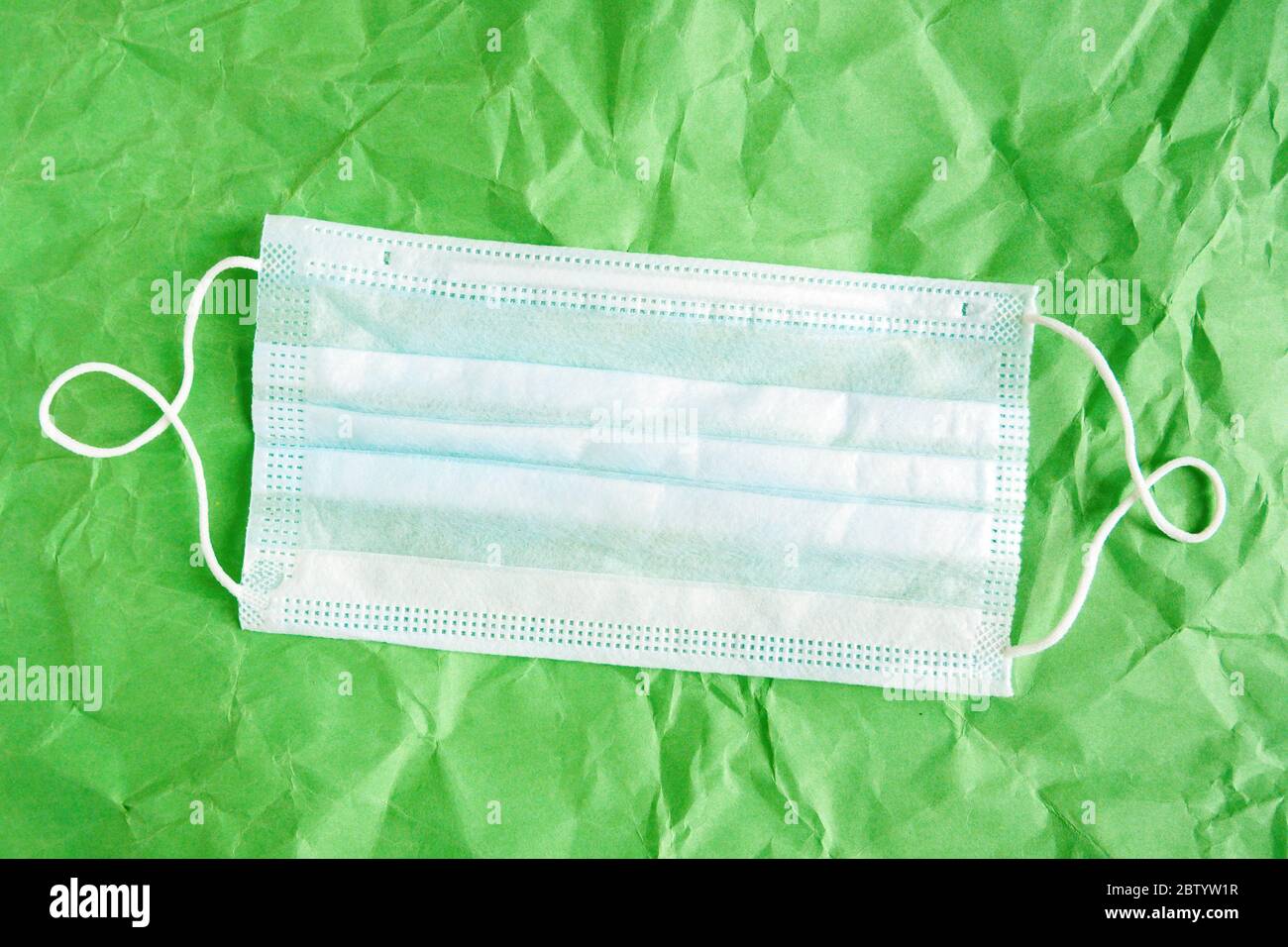 Medical mask on crumpled green paper, top view Stock Photo - Alamy
