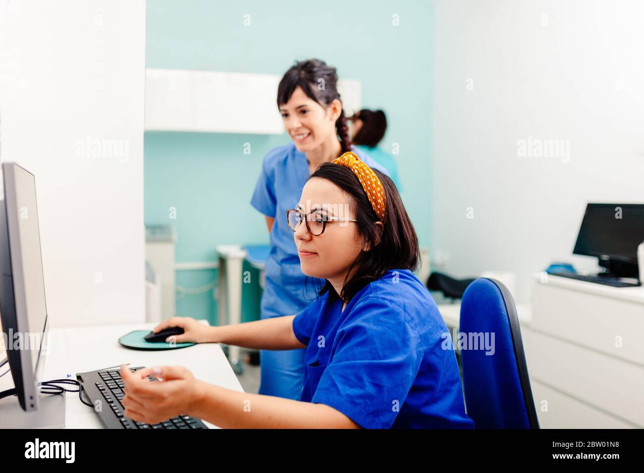 Two nurses using a computer in a x-ray room Stock Photo - Alamy