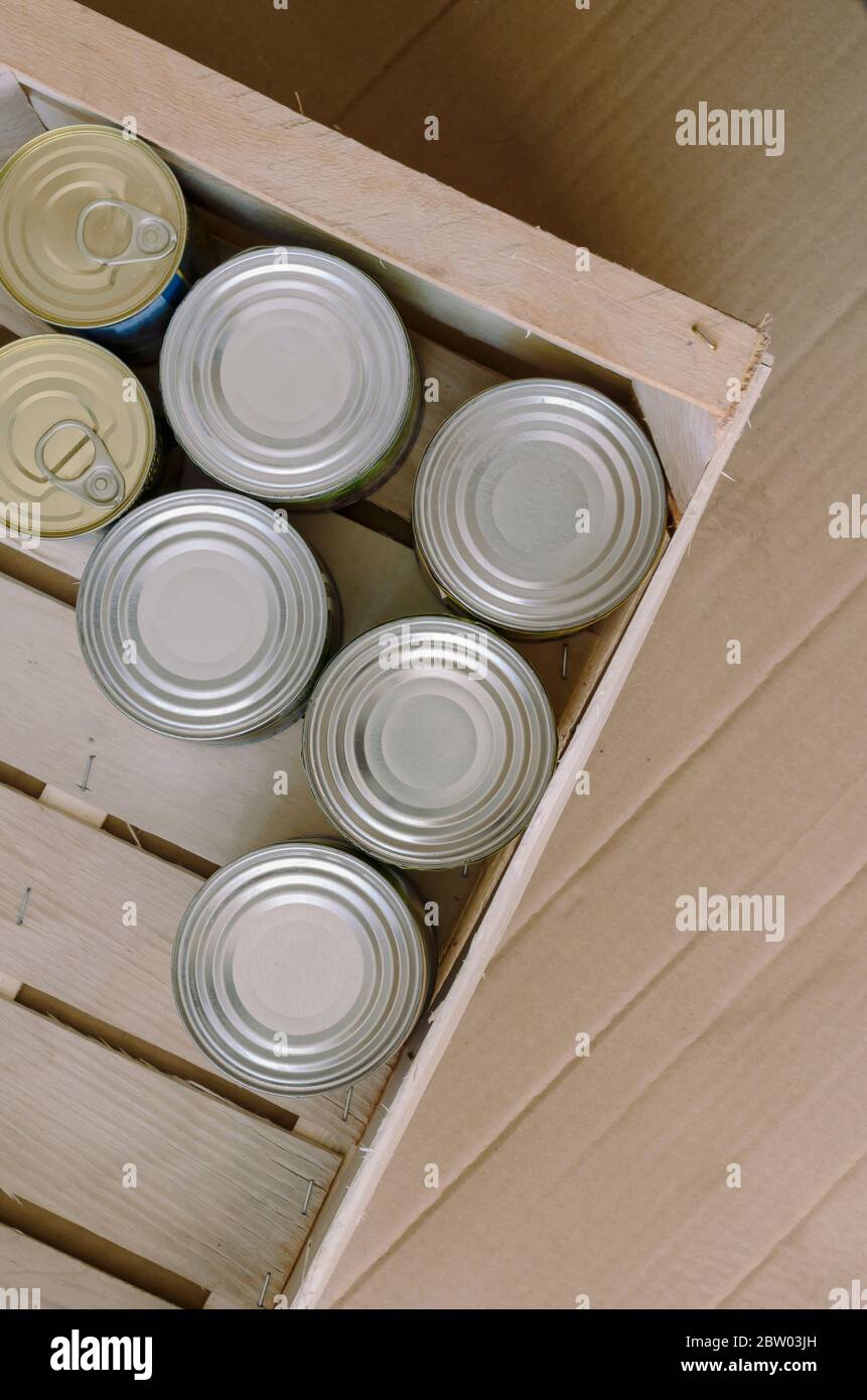 Tin cans in a cardboard box. A variety of canned food in full tin cans ...