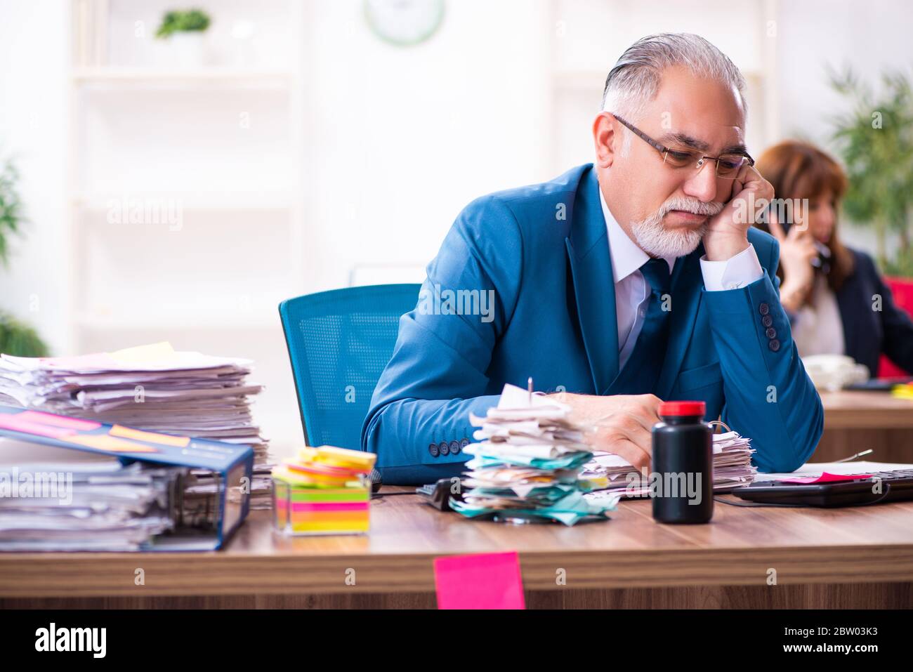 Two employees and excessive work in office Stock Photo - Alamy