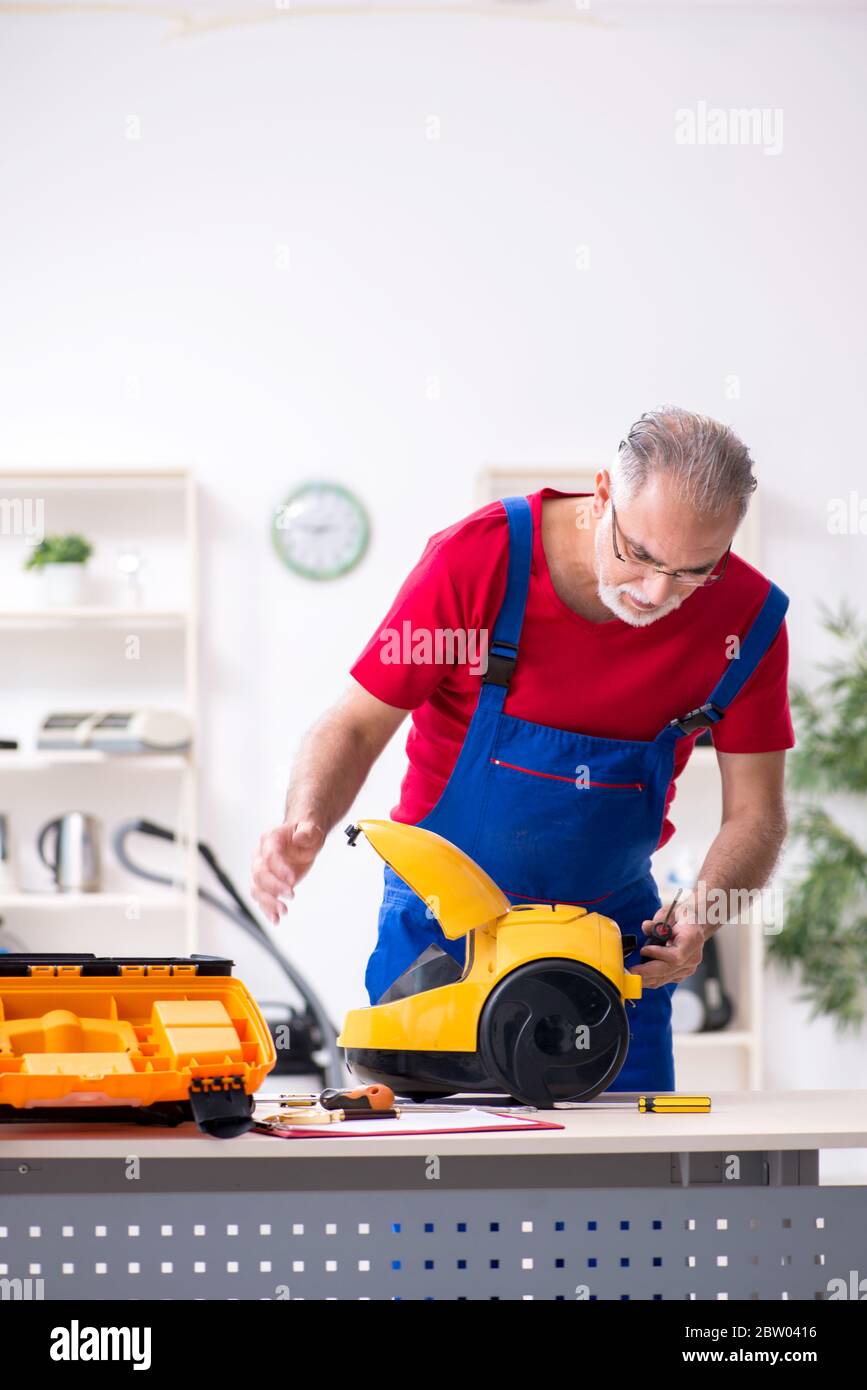 Old repairman repairing appliances in his workshop Stock Photo - Alamy
