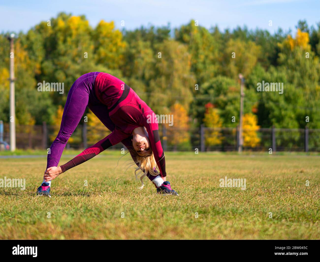 Photo of a flexible woman stretches outdoor. Healthy lifestyle concept ...