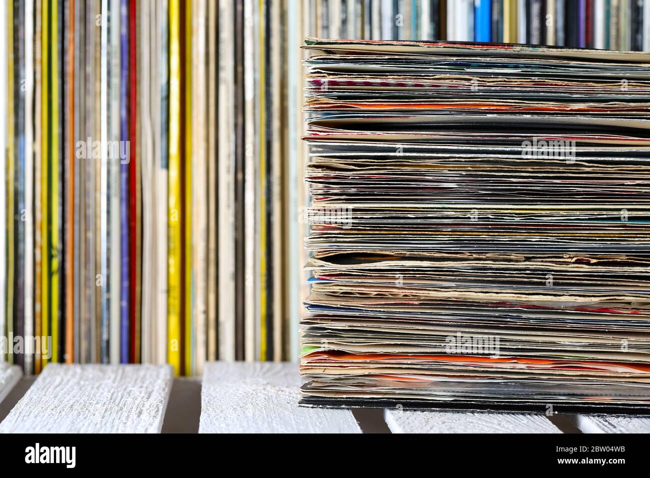The vinyl records are stacked and other vinyl records on the shelf are ...