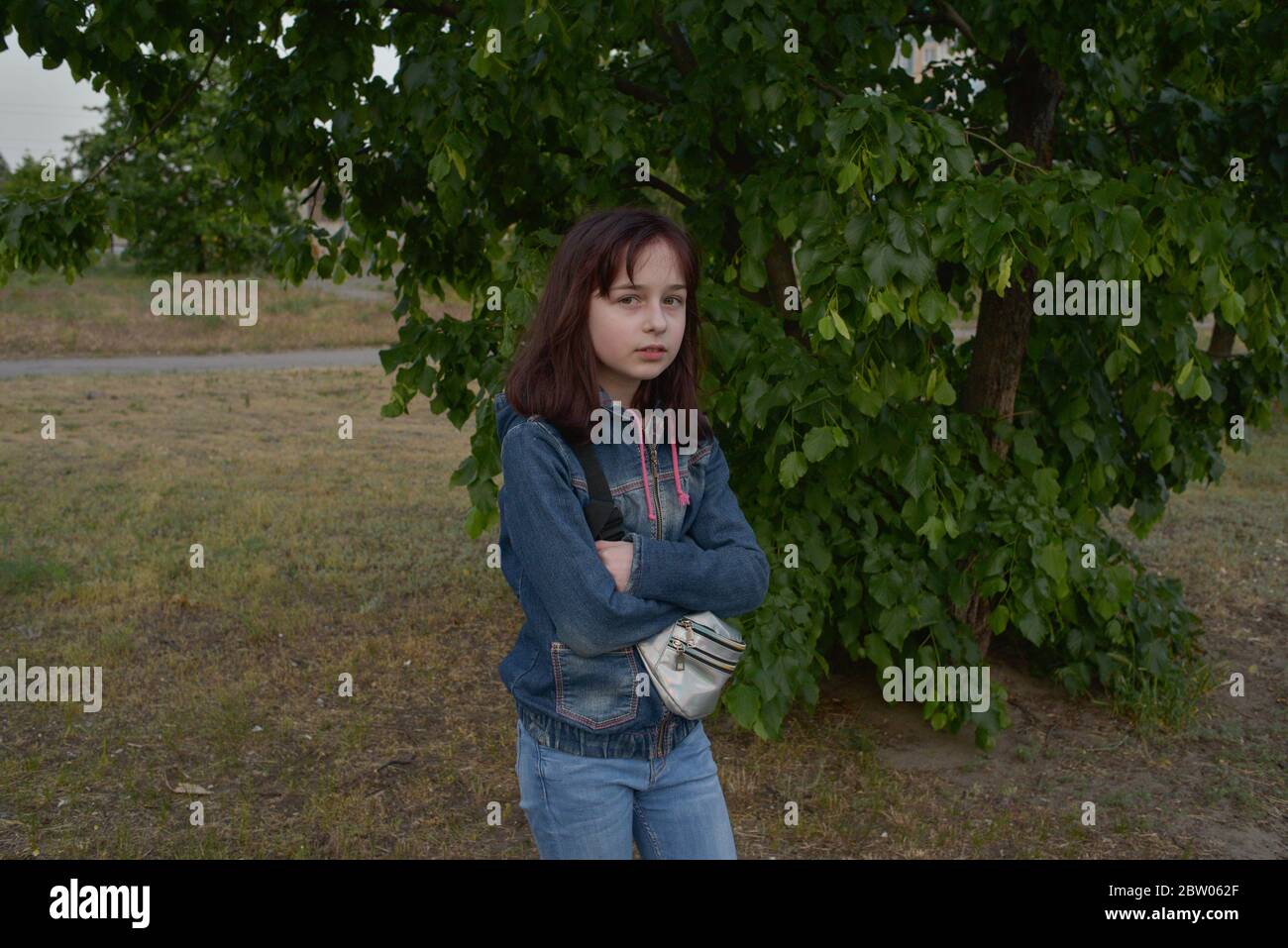 Outdoor funny portrait of a cute little 9-10 year old girl wearing ...