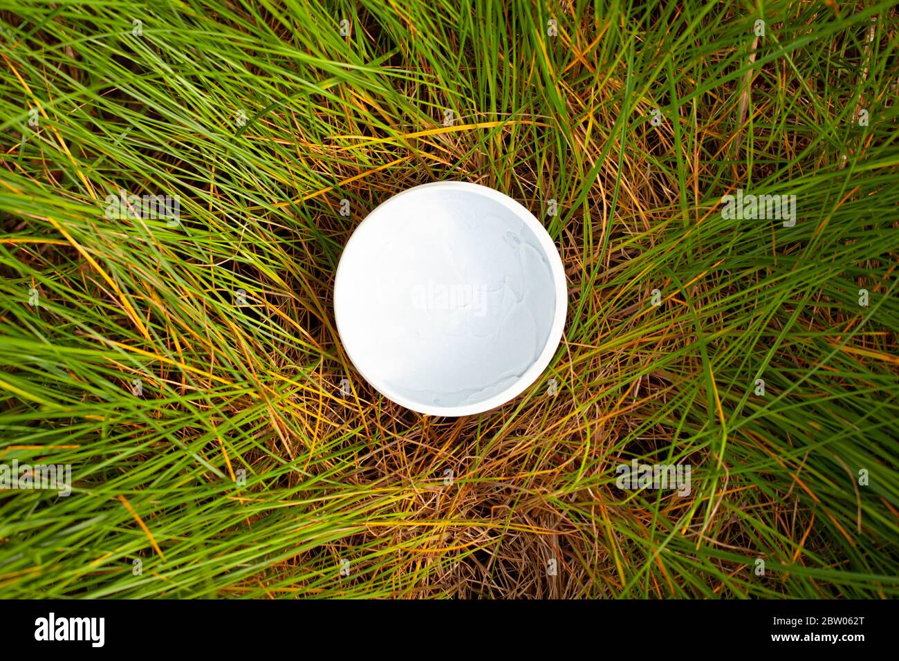 white round body scrub on green grass top view, skin care cosmetics ...