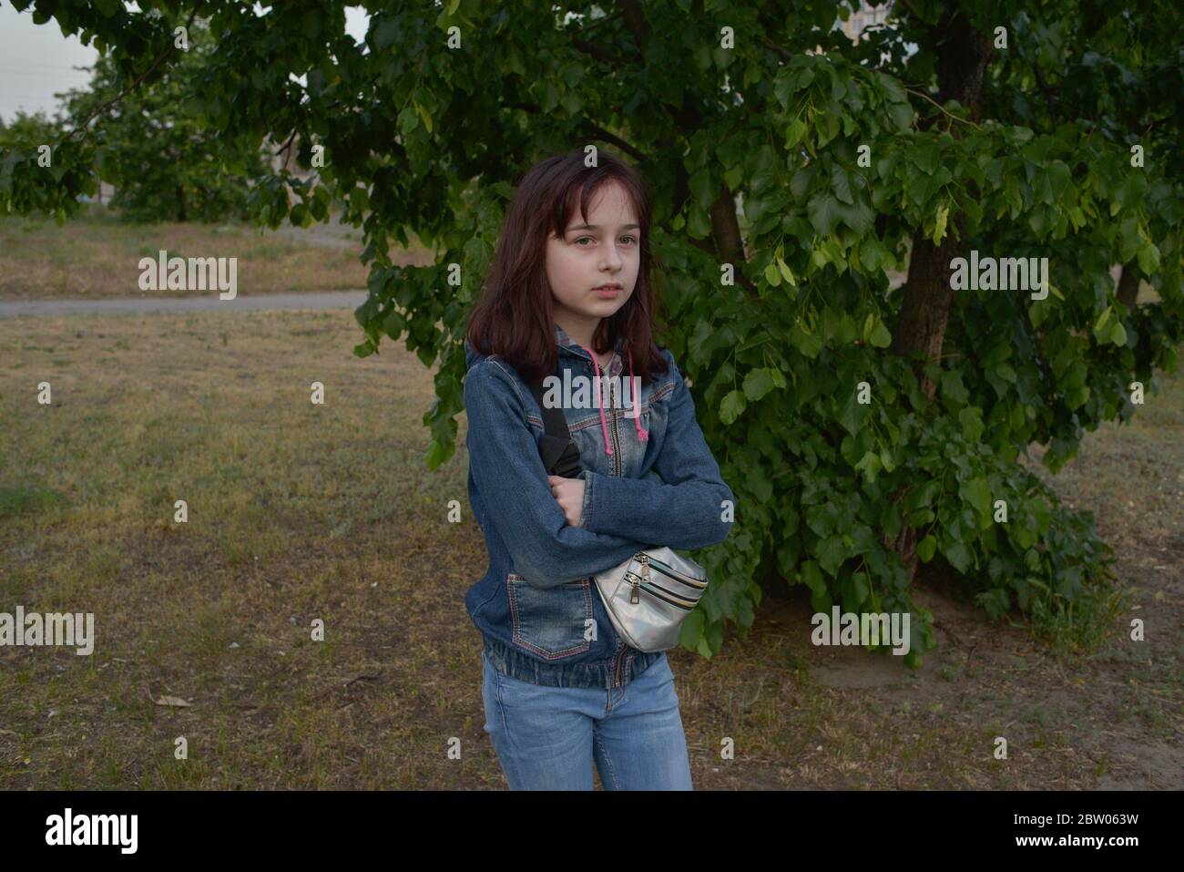 Outdoor funny portrait of a cute little 9-10 year old girl wearing ...