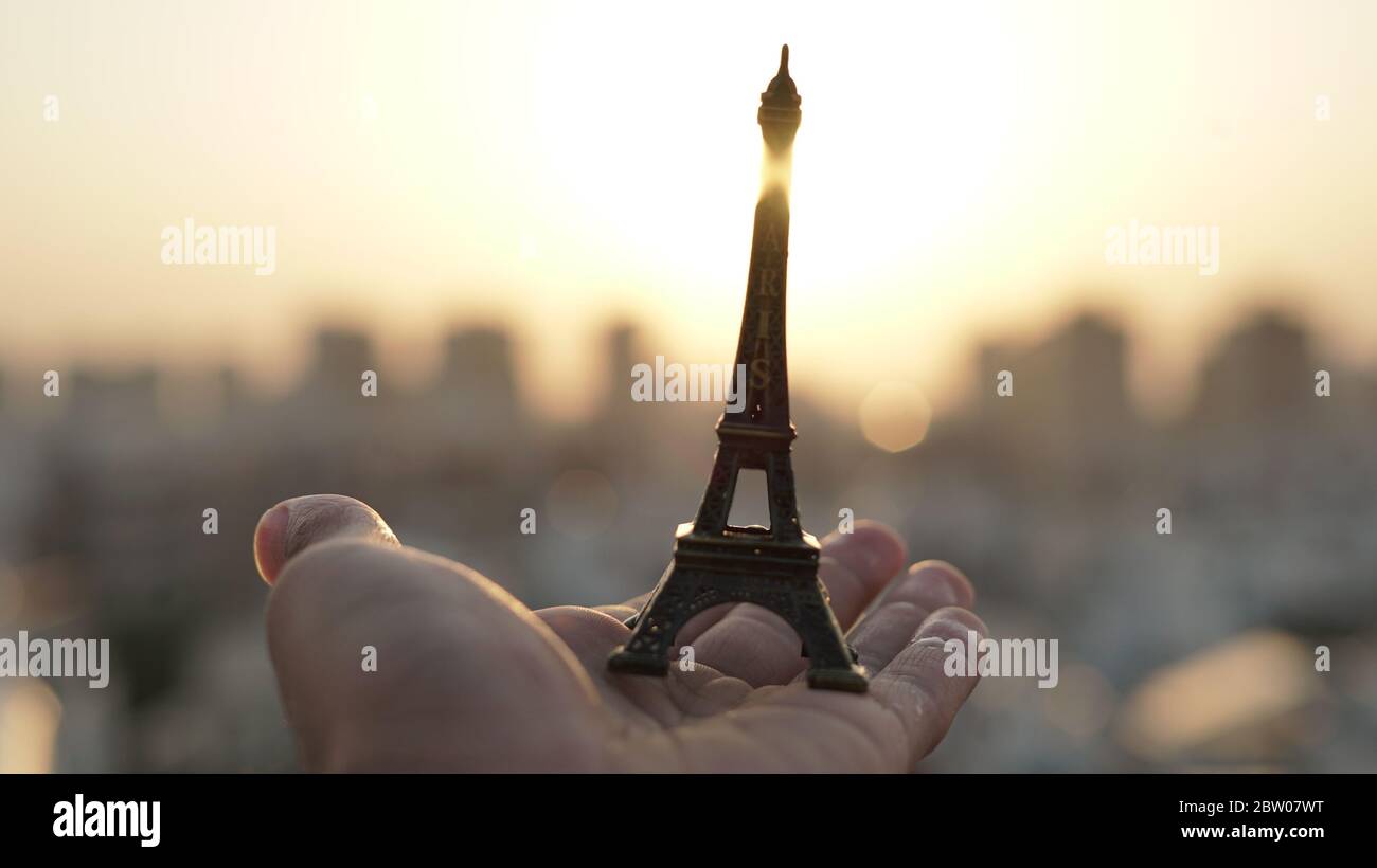 Man hand holding small Eiffel Tower over hand Stock Photo - Alamy